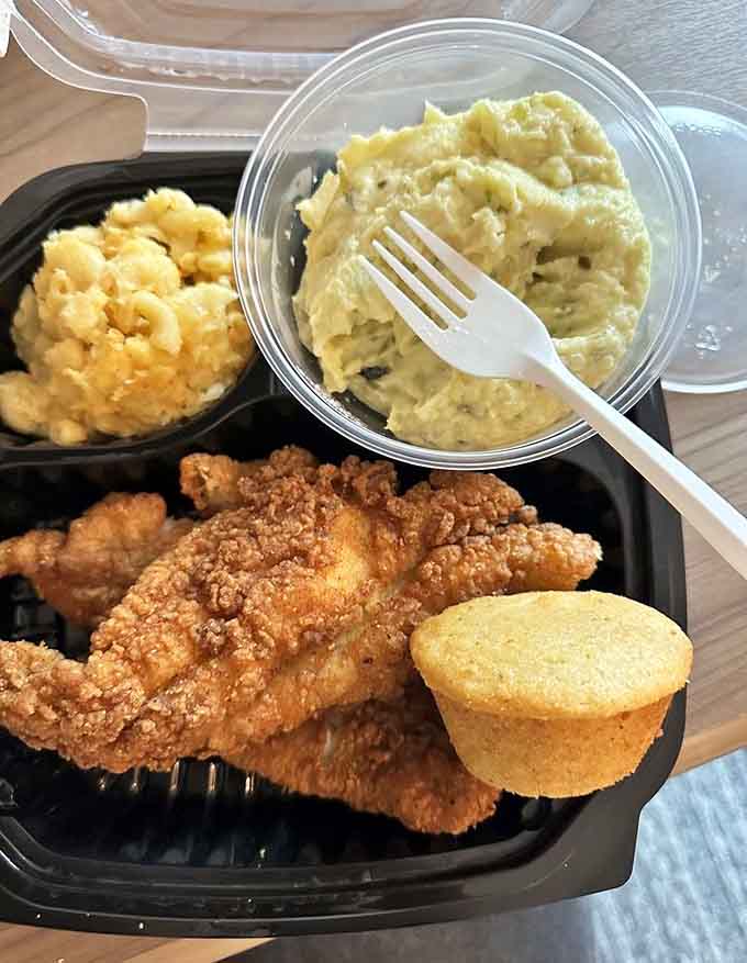Fried catfish with mac and cheese and cornbread muffin: a plate that understands comfort food isn't just sustenance.