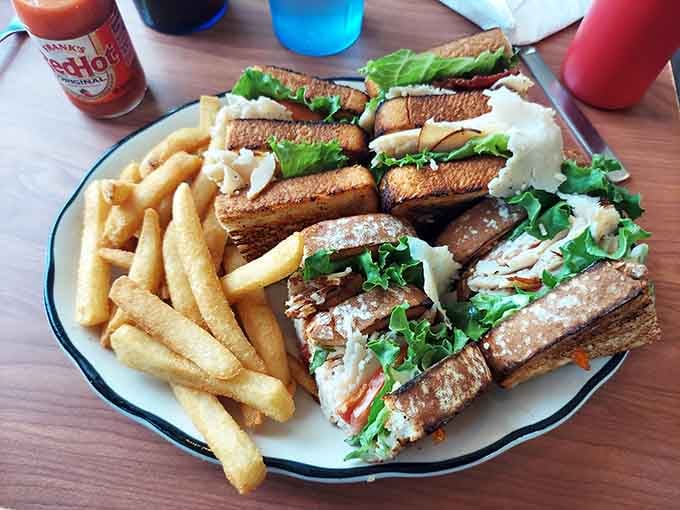 Triple-decker sandwich architecture at its finest, accompanied by perfectly golden fries for good measure.