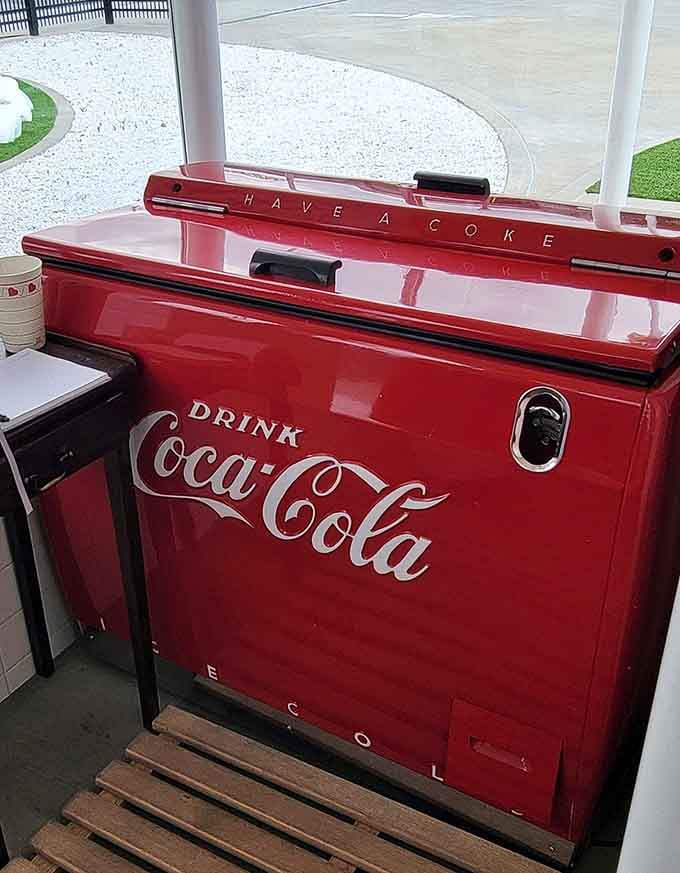 That vintage Coca-Cola cooler with its cheerful red finish practically begs you to grab an ice-cold bottle.