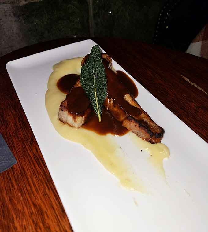 Pork belly with sage leaf presentation that would make your grandmother's Sunday roast jealous of its sophisticated plating style.