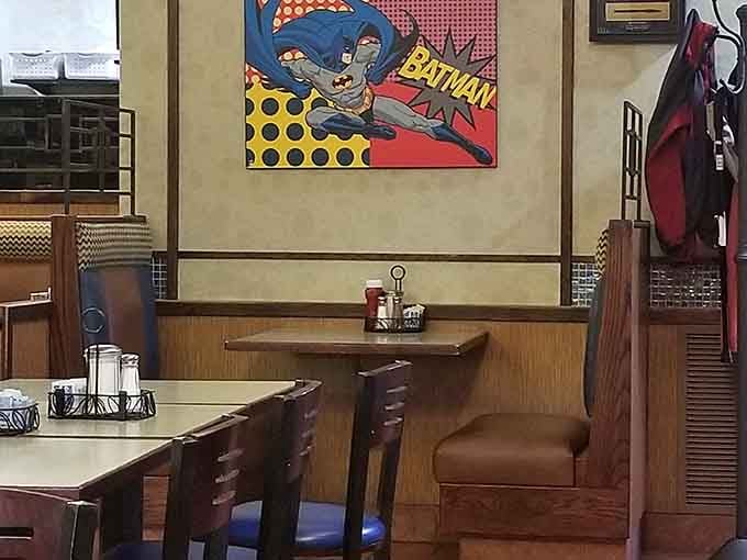 Colorful Batman posters watch over cozy booths, making every meal feel like dining in the world's friendliest Batcave.