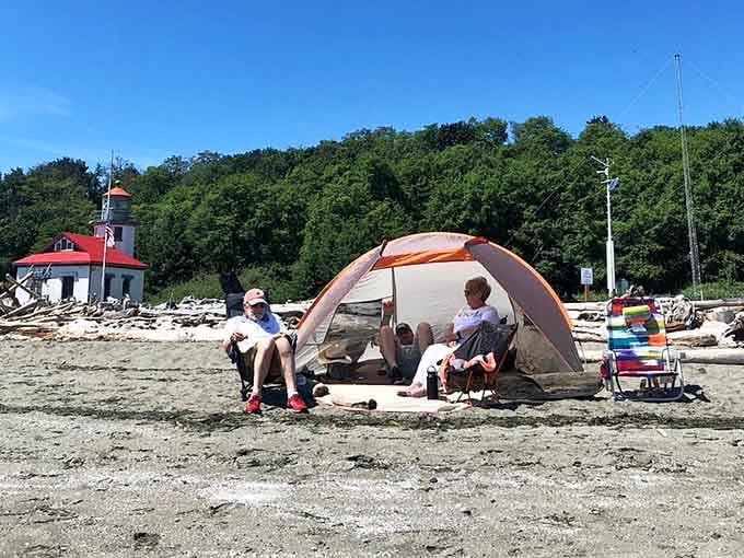 Sandy beaches and driftwood provide the perfect backdrop for tent camping with a lighthouse view included free.