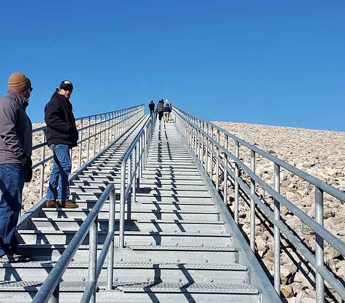 Visitors climb the observation deck stairway, heading toward panoramic views that stretch across the entire Missouri River valley below.