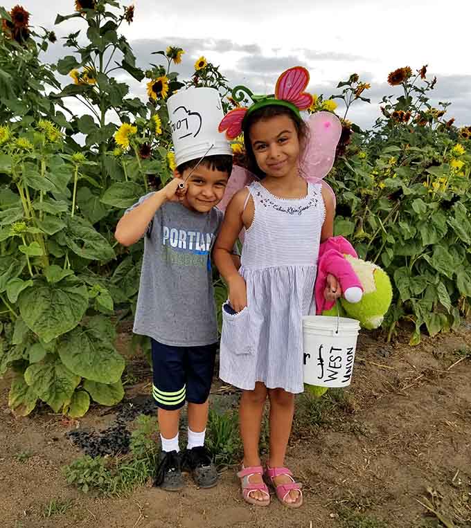 Young adventurers pose proudly with their harvest, already planning which flowers get the best spot at home.