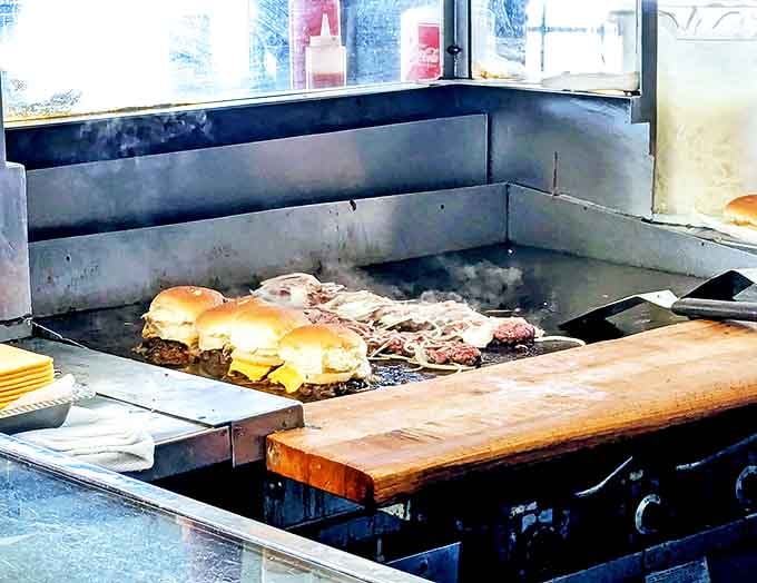 The griddle where magic happens daily, transforming simple ingredients into legendary burgers before your very eyes.