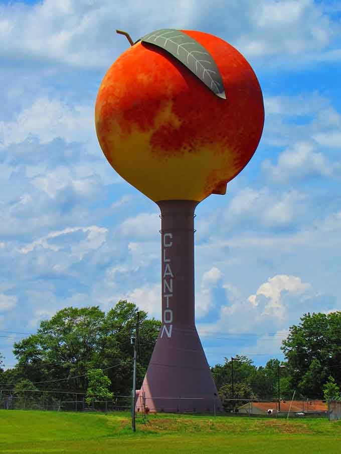 That giant peach glows against blue skies like something from Roald Dahl's imagination, complete with a perfectly placed green leaf!