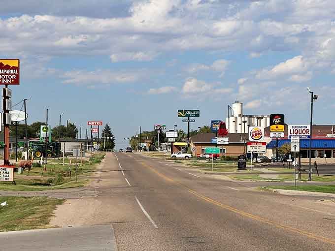 Classic small-town America stretches along the highway where grain elevators stand tall against endless prairie skies.