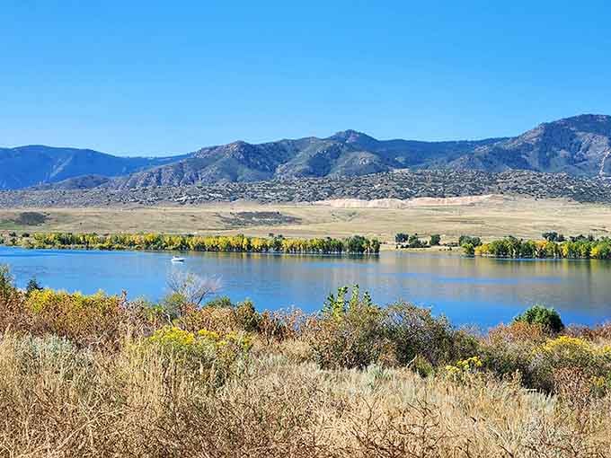 Golden prairie grasses framing blue water with distant peaks&mdash;the kind of vista that inspired all those Western paintings.
