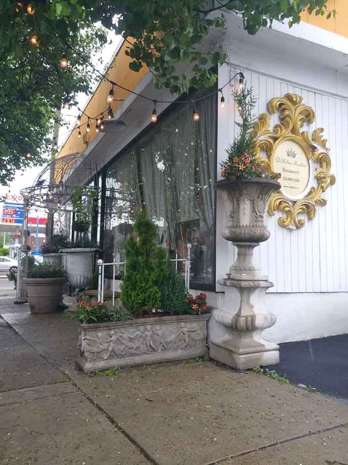 String lights and stone planters frame this inviting facade where Old World elegance meets neighborhood warmth and authenticity.