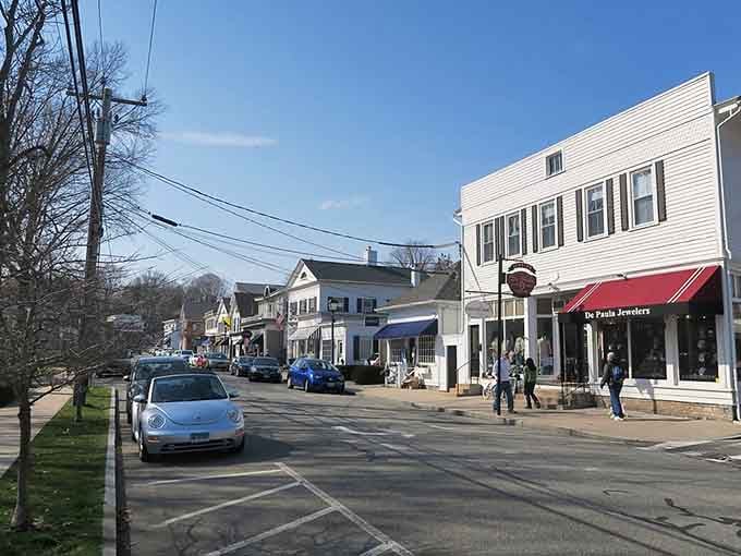 Classic white storefronts with black shutters line the sidewalk inviting you to slow down and browse.