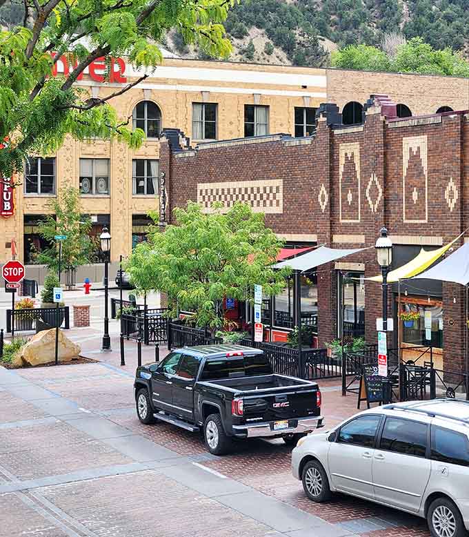 Historic brick buildings frame tree-shaded streets where outdoor dining and mountain views come standard with every meal order.