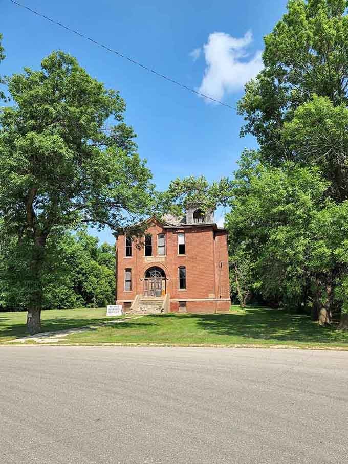This weathered Louisburg schoolhouse, framed by summer green, carries the quiet dignity of a building that has seen generations come and go.