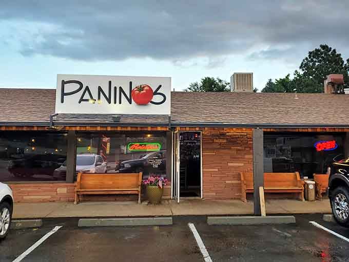 Simple storefront charm with wooden benches inviting you to slow down and savor authentic Italian comfort food.