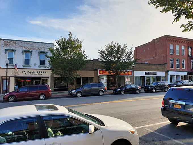 Sunlight warms the historic storefronts of Seneca Falls as you stroll past local shops on this quiet, charming downtown street.