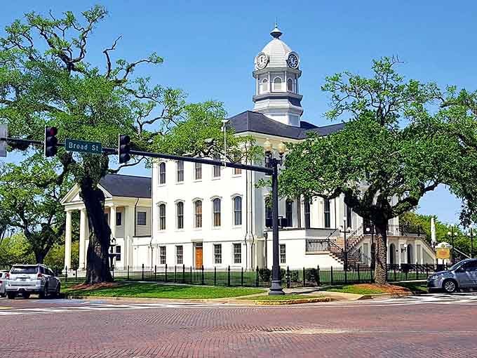 Brick pavement circles the square where history and modern life shake hands under the shade of towering oak trees.