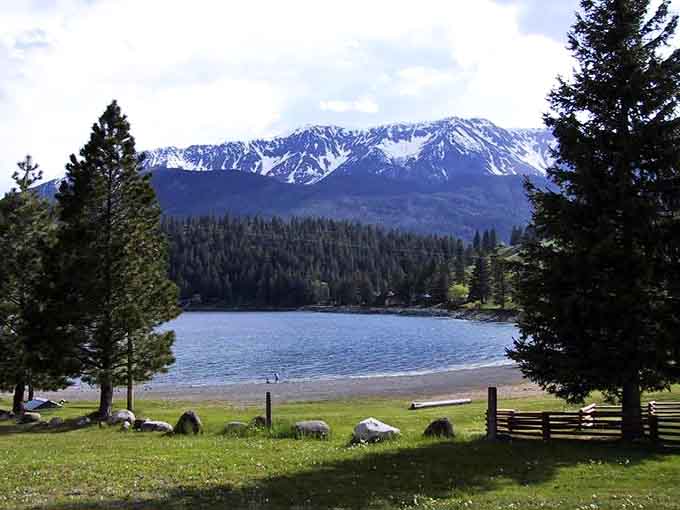 Snow-capped peaks tower above this pristine alpine lake where the water reflects mountains like nature's own perfect mirror.
