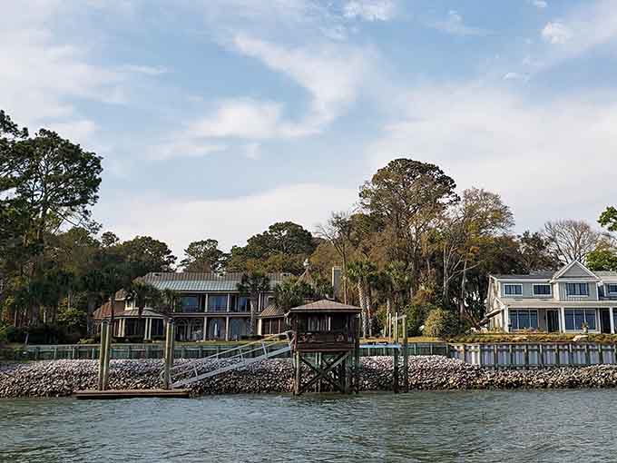 Peaceful waterside homes nestle among ancient trees, creating a scene that belongs on a postcard from paradise itself.