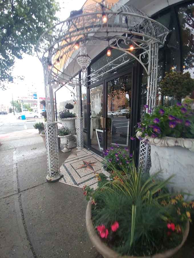 The wrought-iron archway and twinkling lights create an entrance worthy of a romantic Italian film from the 1960s.