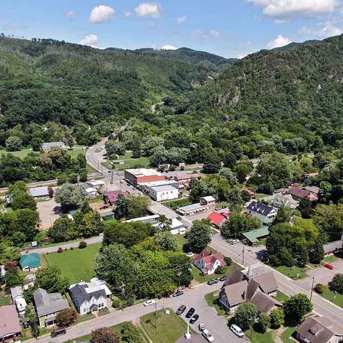 Bird's-eye view reveals a town cradled by green mountains, showing how small communities nestle into nature's embrace.