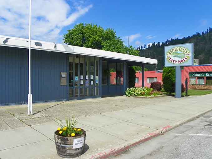 Modest city hall with cheerful planters shows how small communities govern themselves with practical simplicity and genuine civic pride.