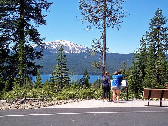 Travelers pause at the overlook where mountain and lake create a postcard-perfect scene worth every mile driven.