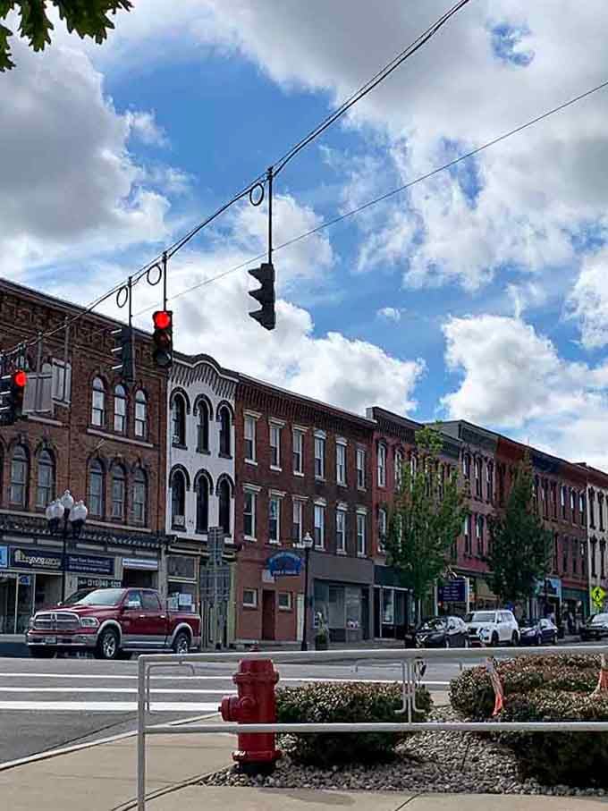 Classic storefronts line the quiet street under dramatic skies, creating an atmosphere where time slows down to a more civilized pace.
