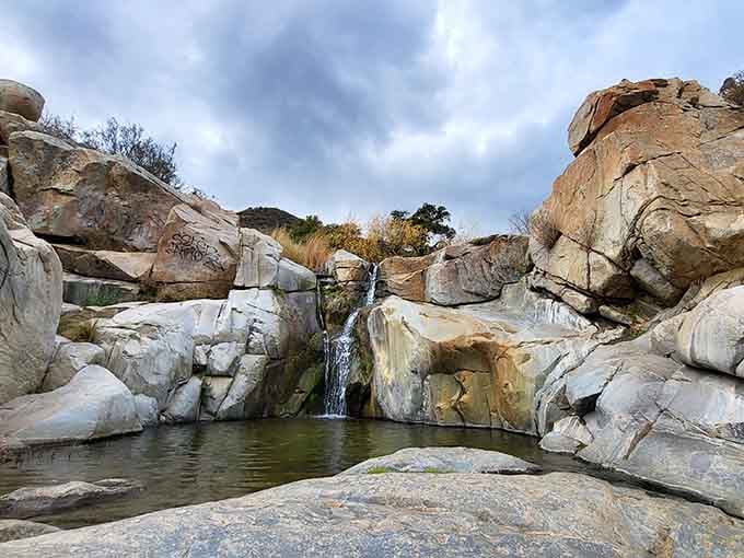 Dramatic boulders frame this intimate waterfall like nature's own sculpture garden, complete with a refreshing pool below.
