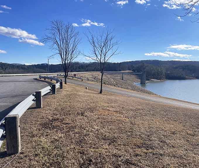 The lakeside road curves gently past bare winter trees, offering peaceful water views that calm the soul instantly.