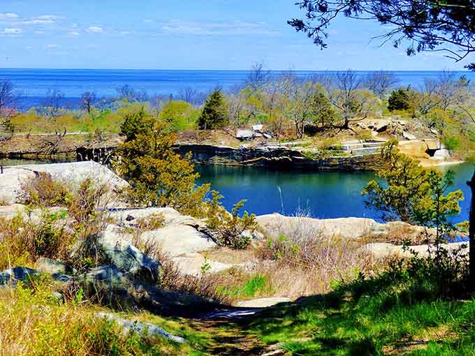 That otherworldly blue-green water filling the old granite quarry looks like something from a fantasy novel come to life.