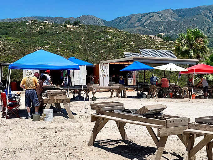 Wooden screening tables stretch across the valley floor, where mountains watch over every hopeful dig.