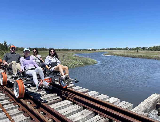 Four riders pause over the marsh under a perfect blue sky, soaking in scenery that no screen can replicate.