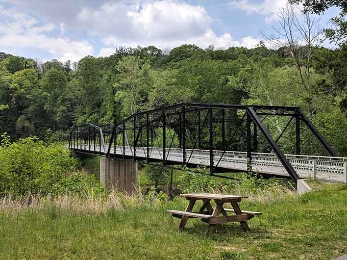 The historic bridge and picnic area provide an ideal setting for a relaxing afternoon surrounded by lush greenery and natural beauty.