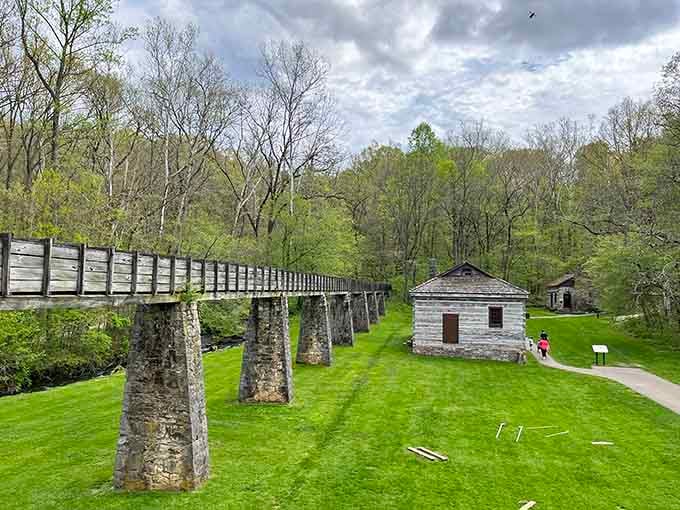 A wooden bridge and stone structures sit quietly in a valley, like time forgot to keep moving here.