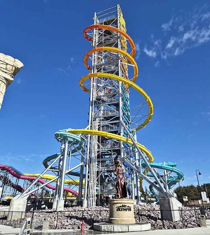 A Mt. Olympus statue stands guard below a towering spiral of colorful slides reaching high into that gorgeous blue Wisconsin sky!