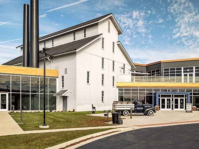Heaven Hill's visitor center sits quietly beneath a big Kentucky sky, with rick houses looming proudly behind it.