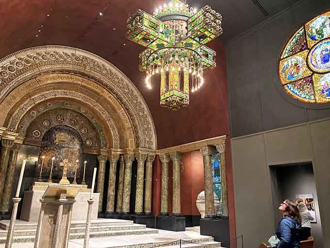 That cross-shaped electrolier dripping with emerald Tiffany glass makes every other chandelier feel deeply inadequate about itself.