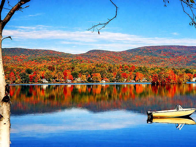 Pontoosuc Lake in full autumn glory, where the Berkshire hills turn every shade of fire and the water mirrors it all back perfectly.