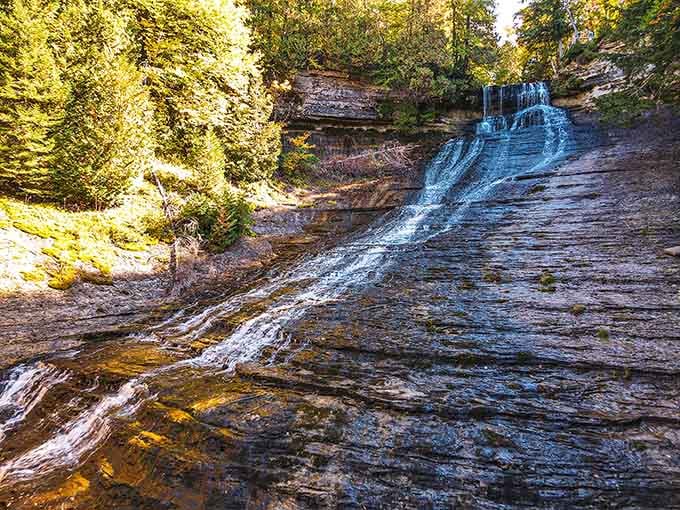 Nature's own curtain call, where the Laughing Whitefish River fans across ancient rock like it owns the place.