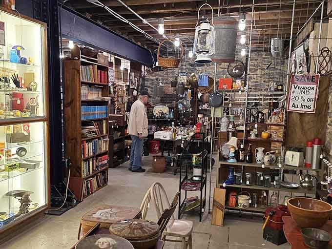 Explore a cozy basement filled with vintage books, hanging lanterns, unique glassware, and fantastic vendor discounts waiting to be discovered.