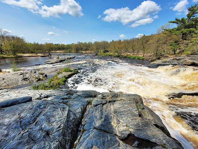 The waterfall cascades over ancient rock formations, creating natural pools and that gorgeous amber-tea colored water that makes this spot special.