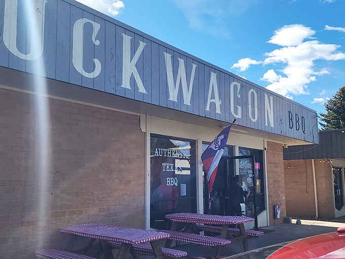 Red checkered tables outside, smoke in the air. This is exactly what a great BBQ spot looks like.