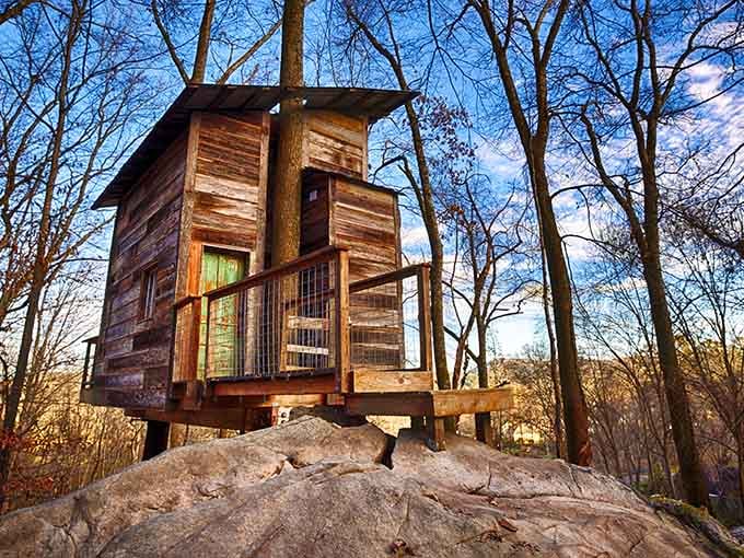 Perched on raw Georgia rock, this weathered treehouse rising against a winter-blue sky is pure storybook magic.