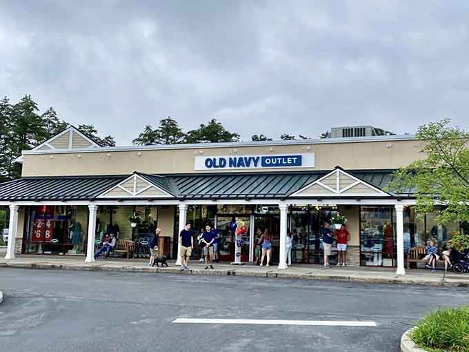That classic outlet mall architecture promising savings inside, nestled perfectly in the Adirondack landscape where shopping meets scenery.
