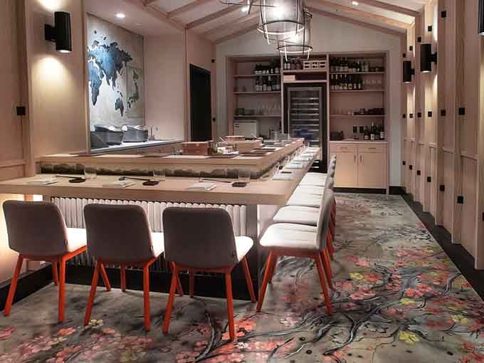 That floral carpet alone is worth the visit, blooming beneath pale wood and warm pendant light like a garden decided to move indoors.