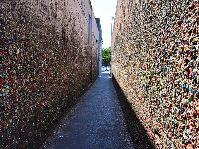 Two walls, zero personal space, and roughly a million pieces of chewed gum staring right back at you.
