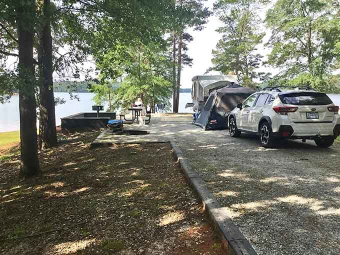 Tall pines, dappled shade, a tent, and a car parked steps from the water. Proof that lakeside camping fits every style.