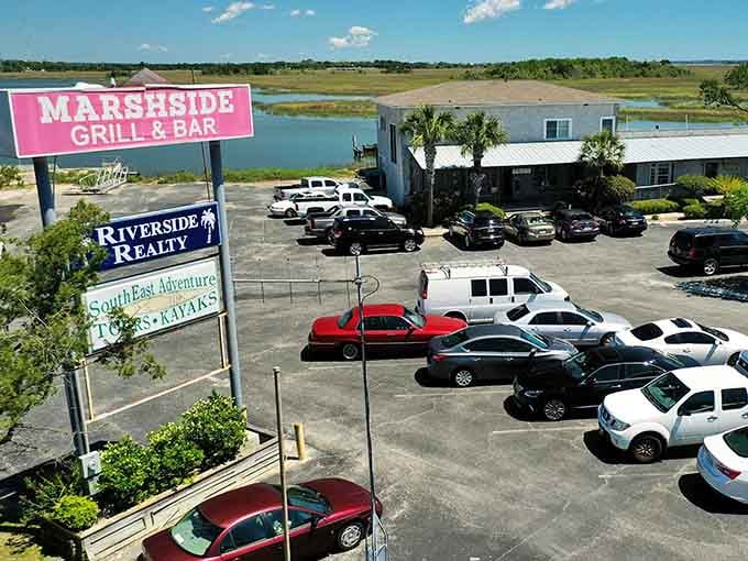 The pink sign says it all, fresh seafood, cold drinks, and marsh views straight ahead.