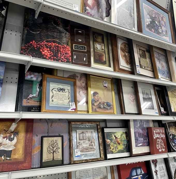 Framed artwork stacked three rows deep, landscapes, portraits, and inspirational prints, basically a gallery where every piece comes with a very reasonable price tag.