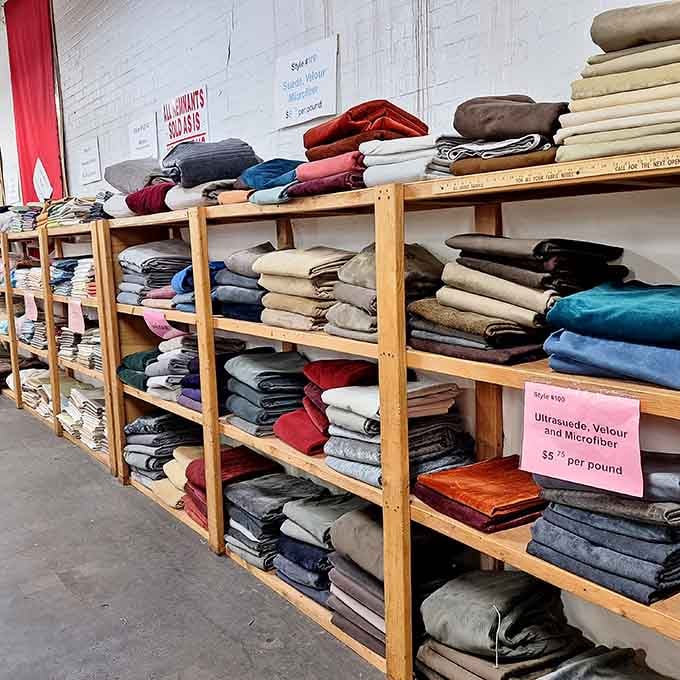 Ultrasuede, velour, and microfiber folded neatly on wooden shelves, soft enough to make you want to touch everything immediately.
