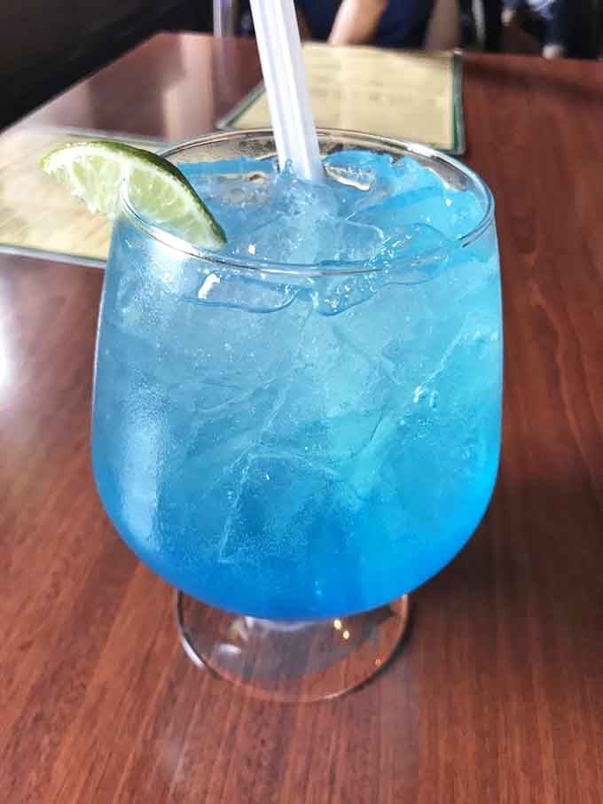 That electric blue cocktail looks like it fell from a tropical sky and landed perfectly in your glass.